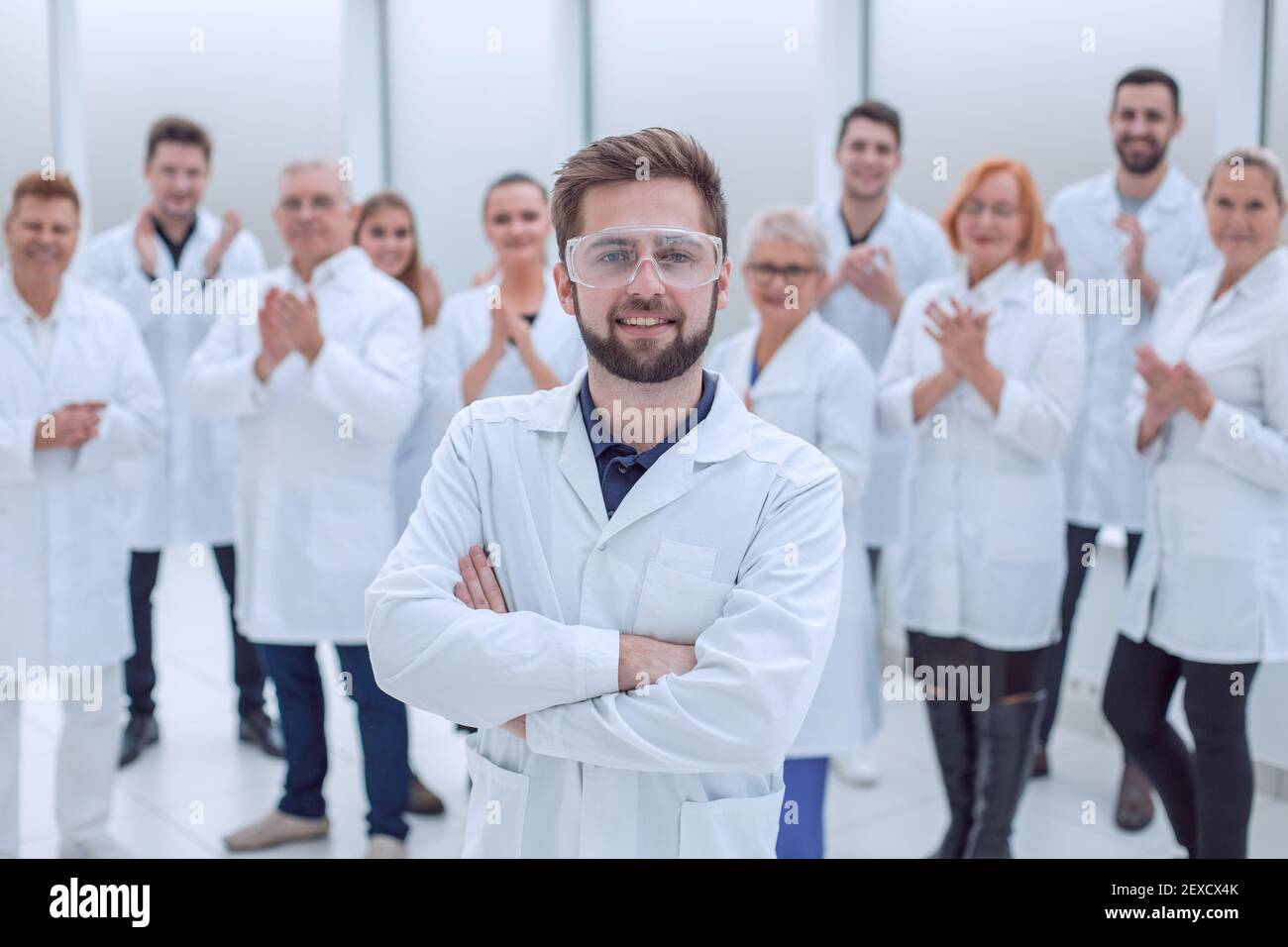 confident scientific leader standing in front of a team of young ...