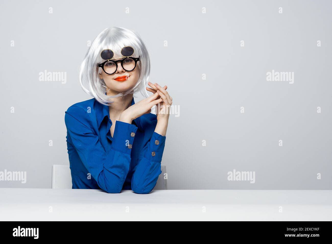 woman takes off white wig from head emotions sit at table cup of drink ...