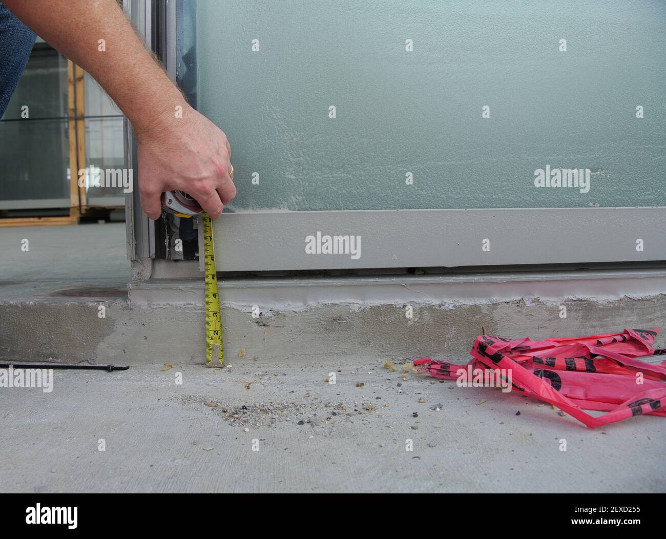 A worker measuring the height of the floor at the construction site ...