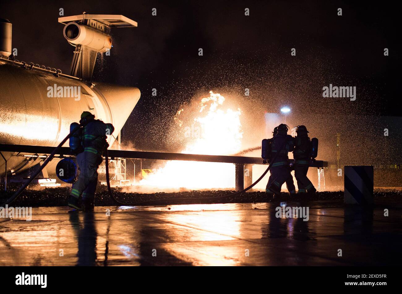 Firefighters and base leadership demonstrate extinguishing an aircraft ...