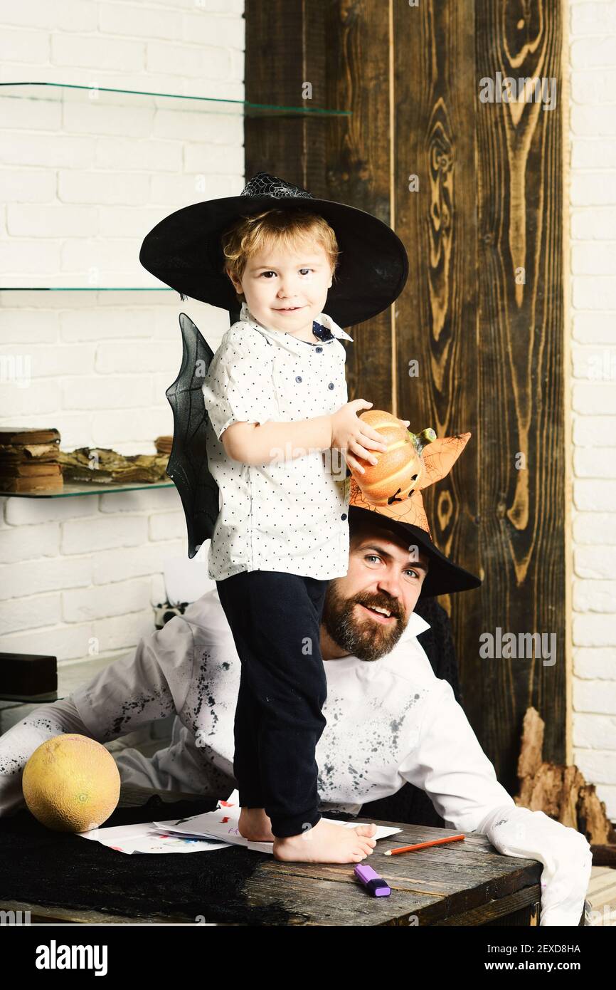 Halloween and party concept. Witcher and little magician decorate room ...