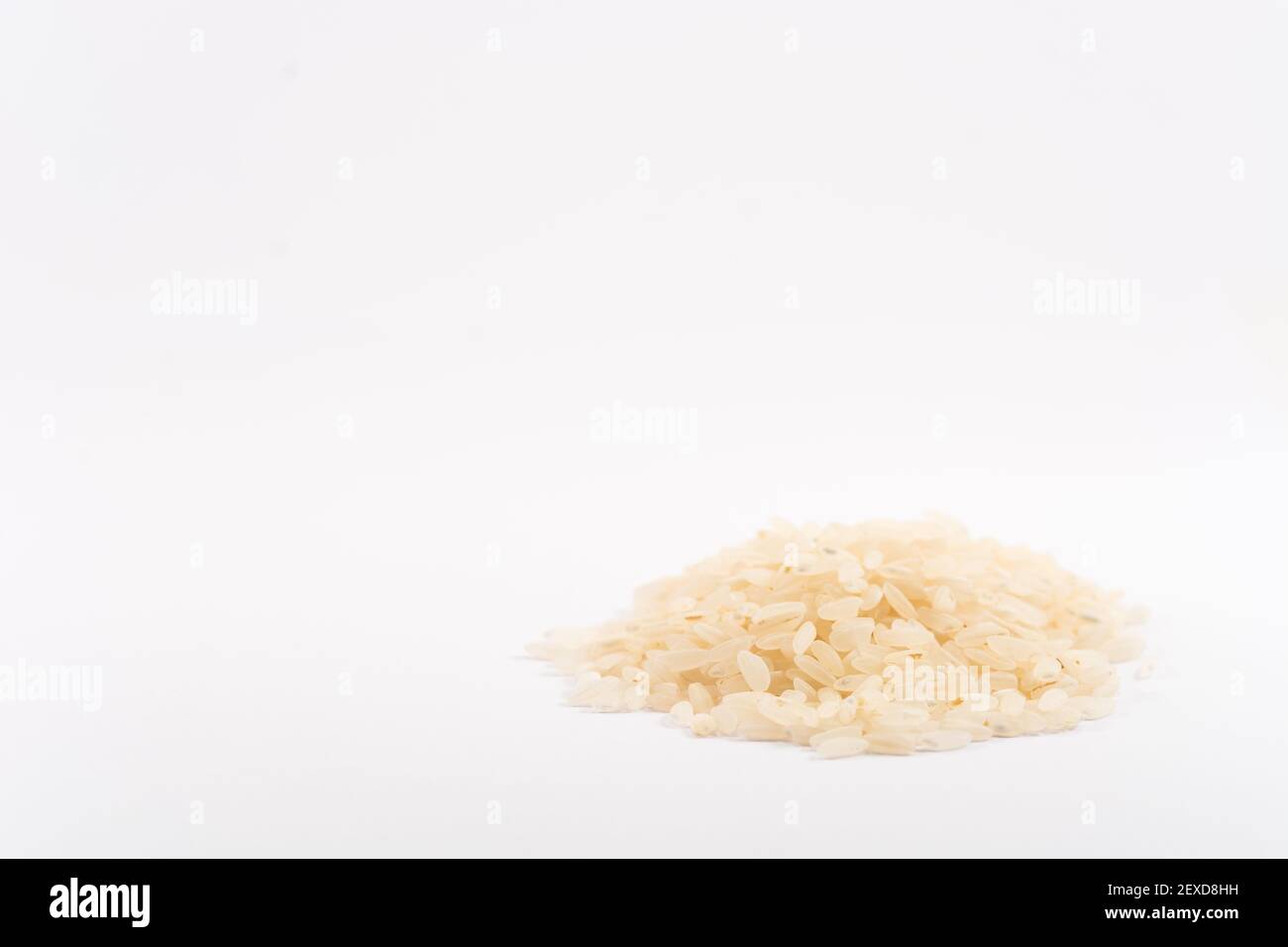 A stack of rice grains on a white background Stock Photo - Alamy
