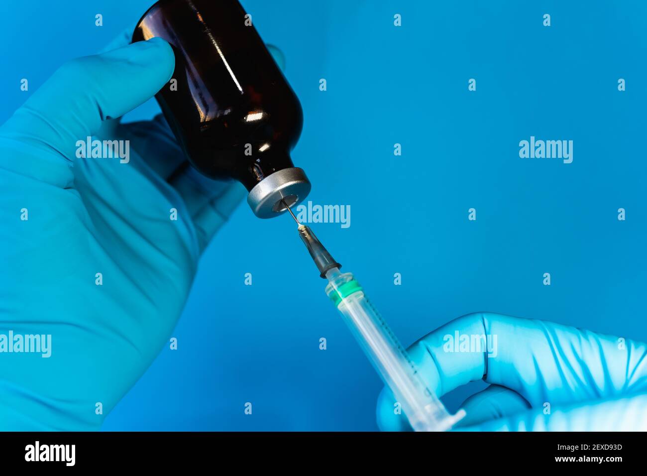 A doctor using a syringe getting ready for the Covid-19 vaccine ...