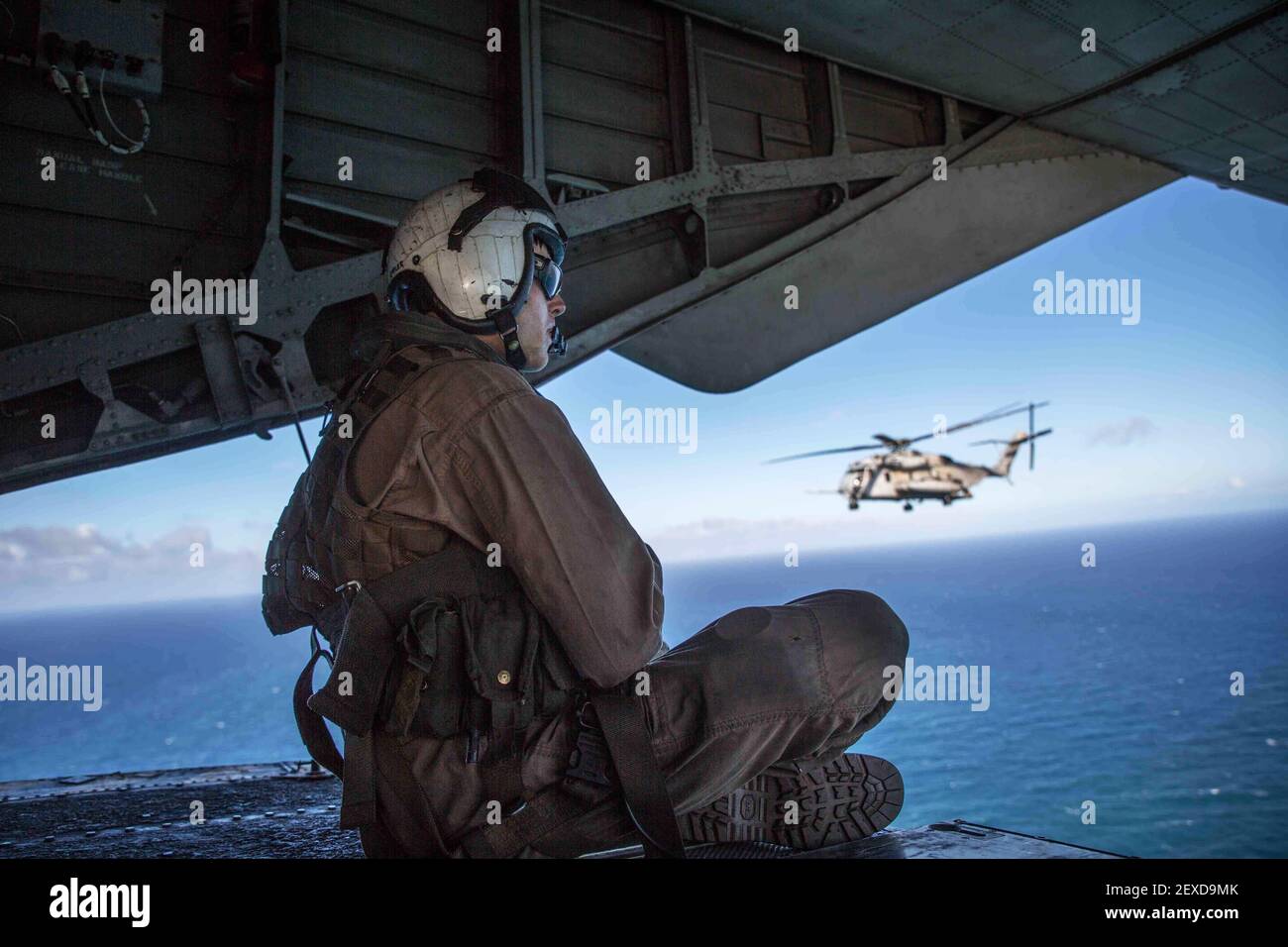 A Marine with Marine Heavy Helicopter Squadron 367 sits on the ramp of ...