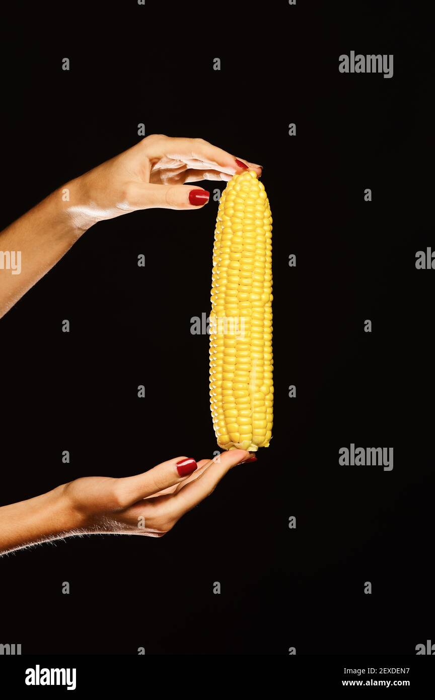 Corn cob in yellow color in girls fingers. Female hand holds corn ...
