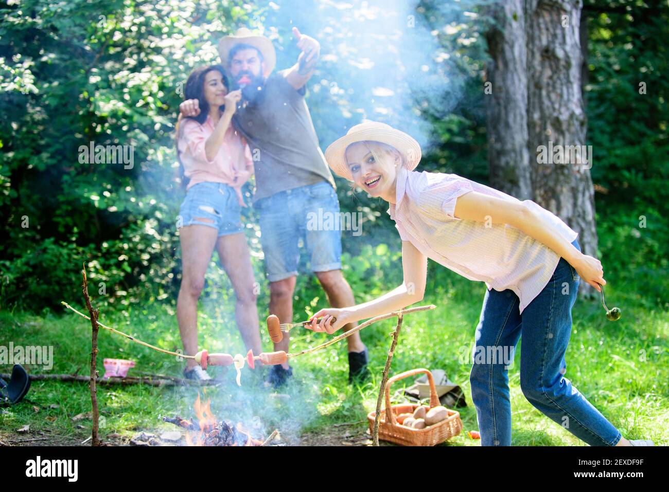 Tips every camper should know about campfire cooking. Girl in straw hat ...