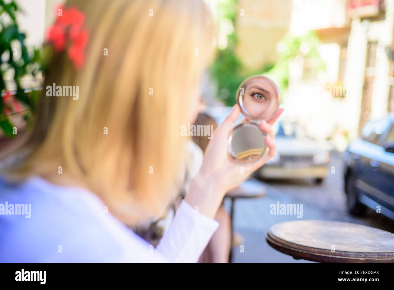Check if everything is right. Woman looking in her pocket mirror ...