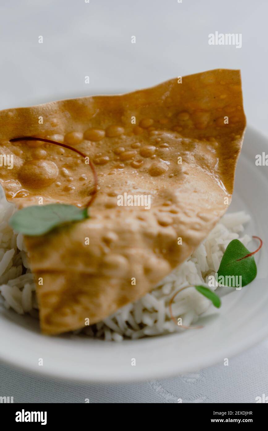 A vertical shot of a serving of boiled white rice with chips and mint ...