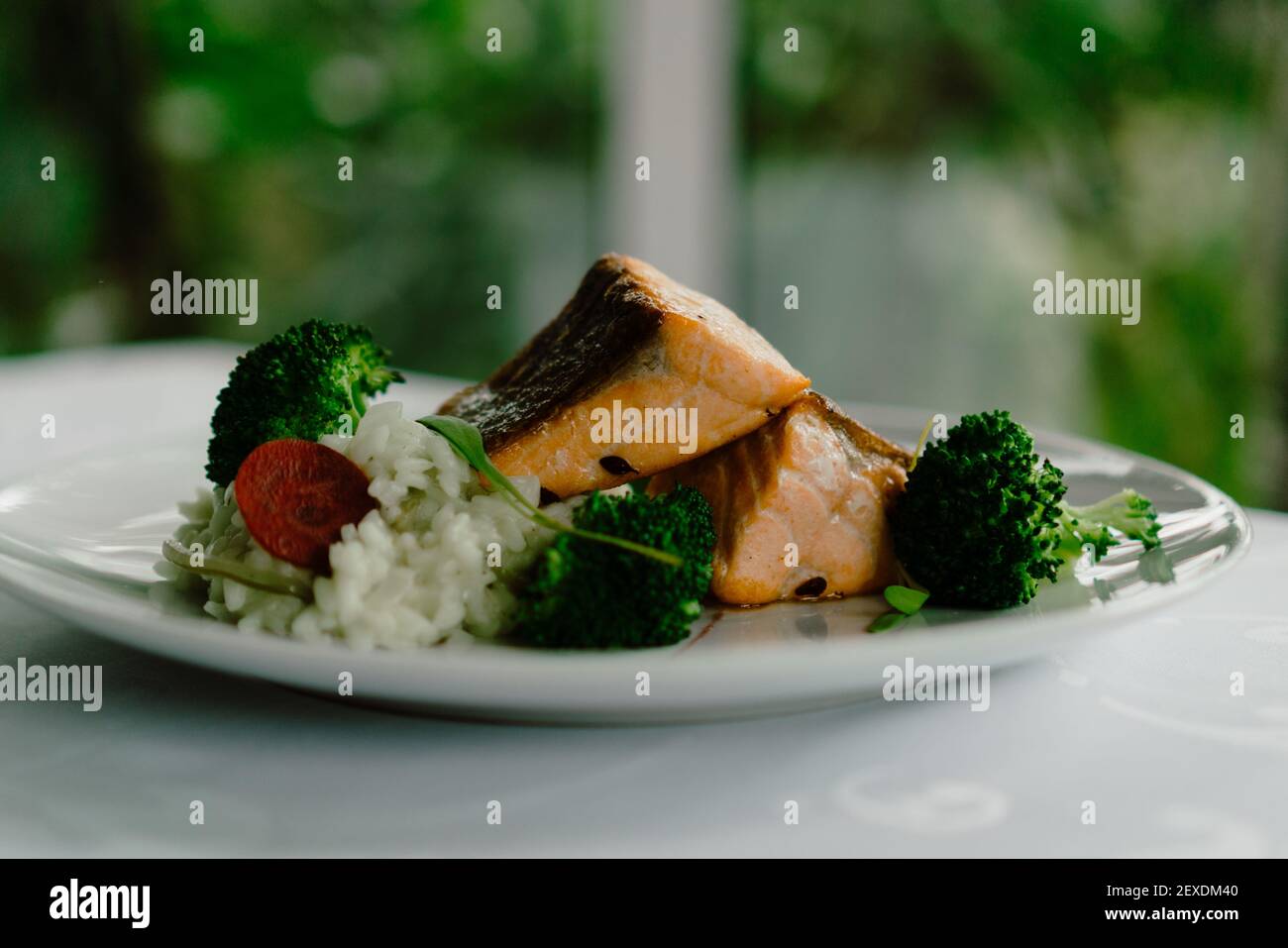 A selective focus shot of a delicious dish with roasted fish, broccoli ...