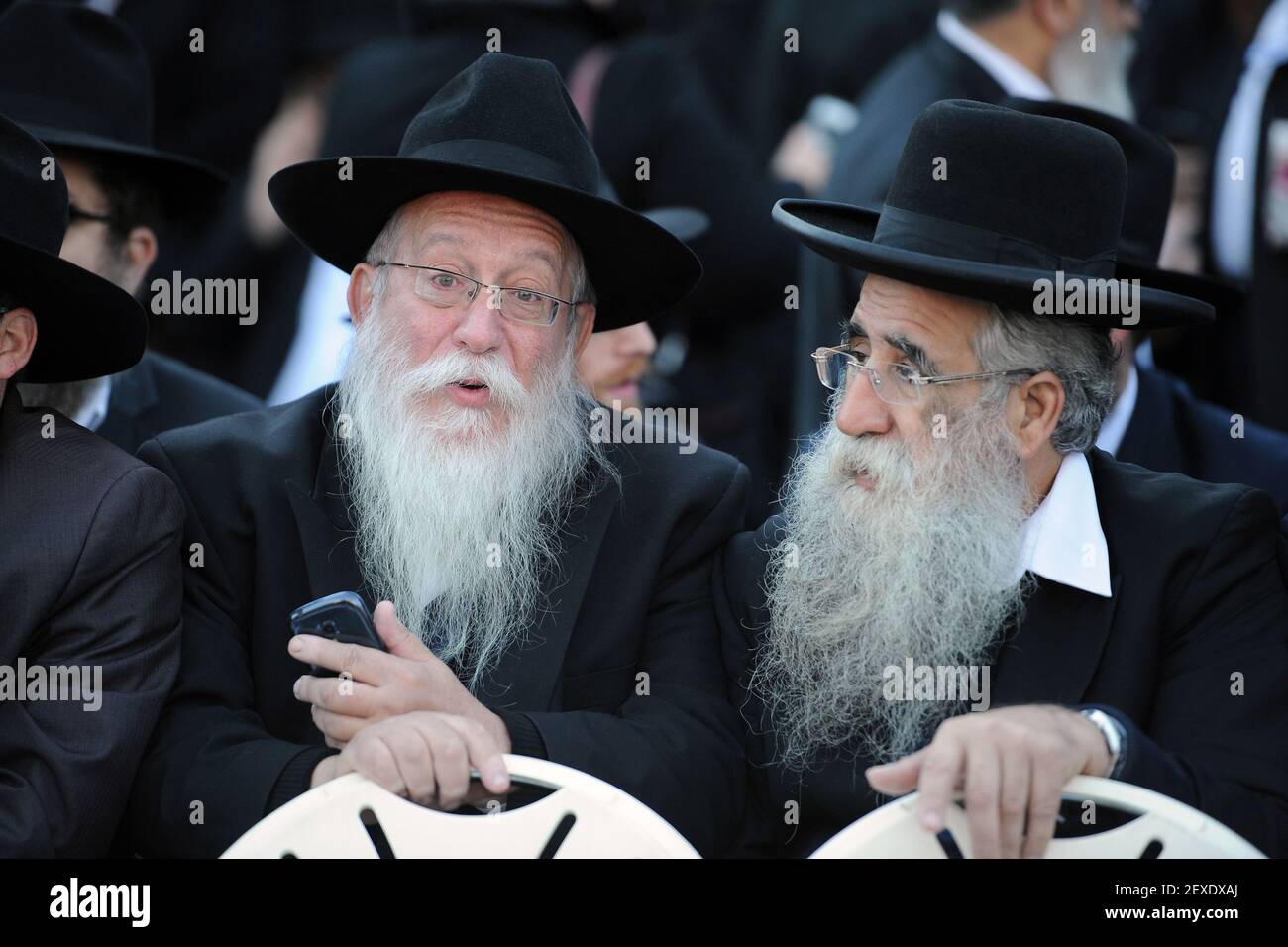 Two rabbis sit and talk as they wait for thousands of rother abbis to ...