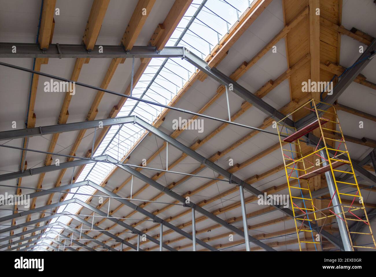 The roof structure of a large hangar consists of a steel frame and ...