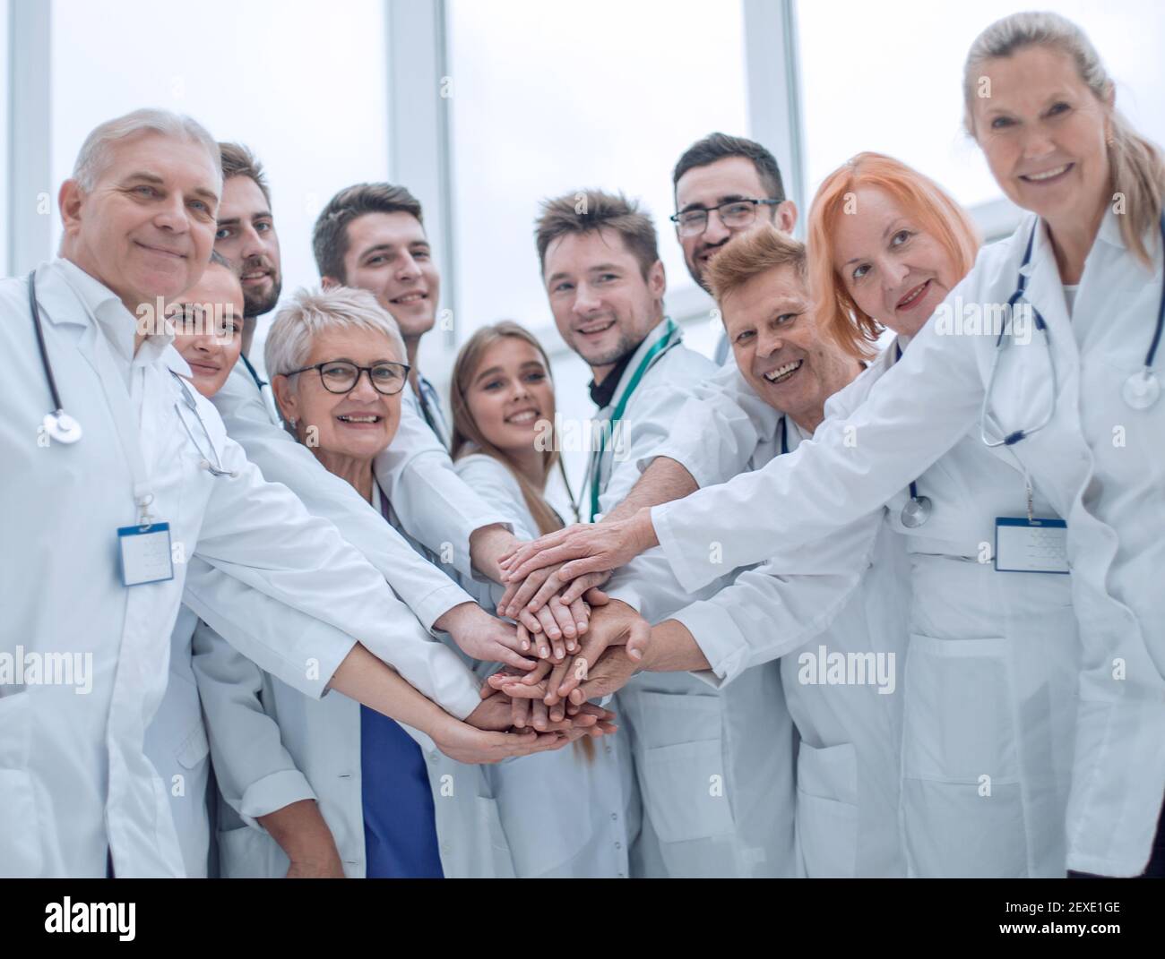 large group of doctors put their hands together Stock Photo - Alamy