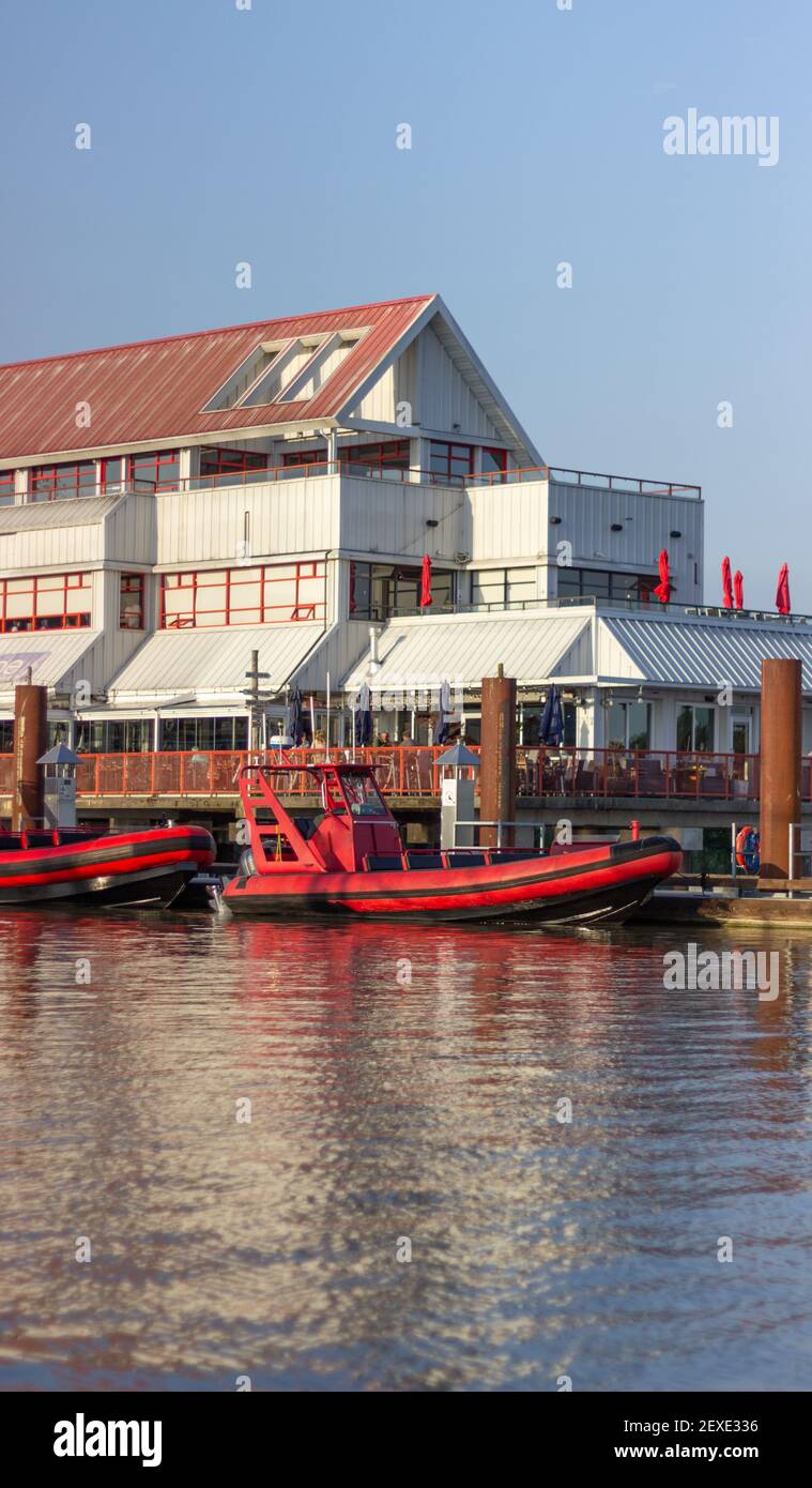 A vertical shot of empty boats in the port near a building Stock Photo ...