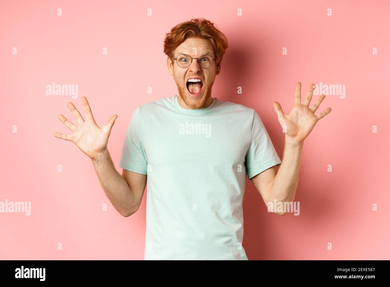 Angry and pressured young man losing temper, spread hands sideways and ...