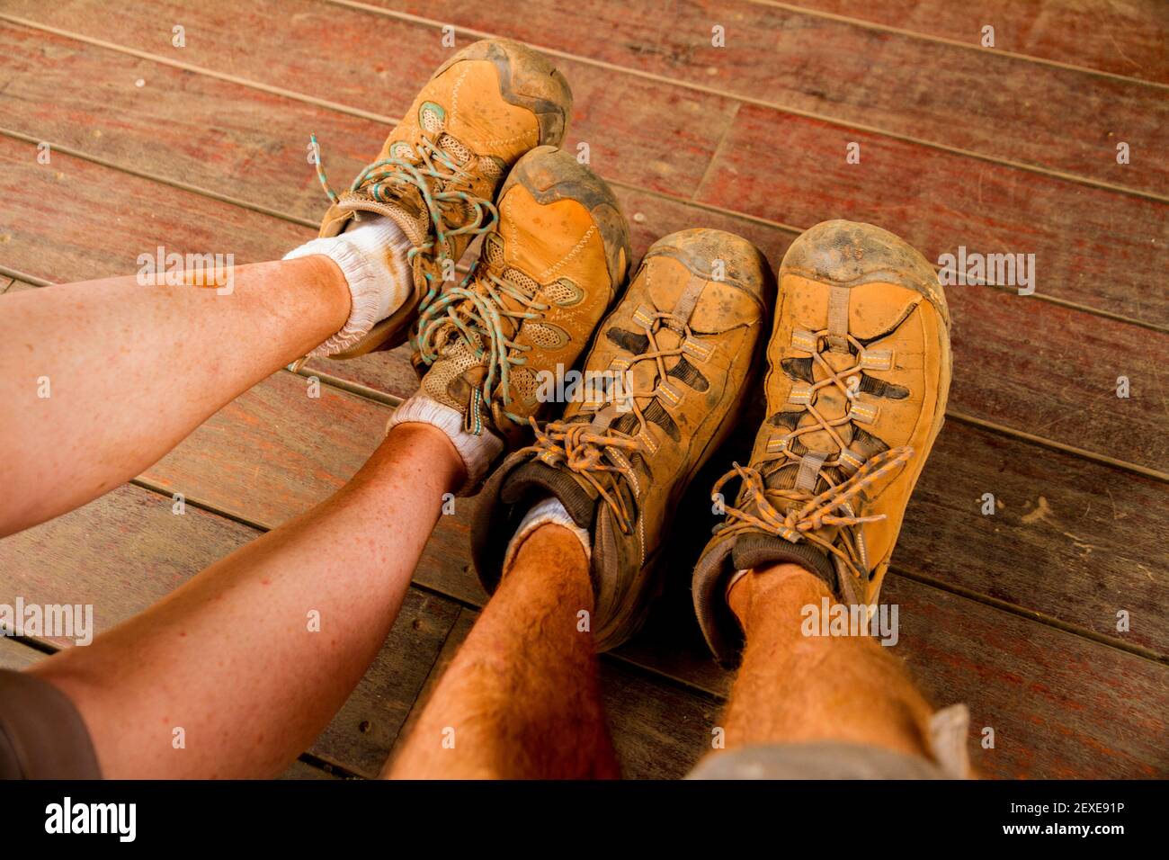 A caucasian woman and man's feet seen inside very dirty hiking boots ...
