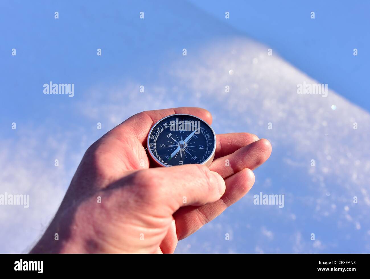 Compass in hand on snow background. Orientation on terrain in forest ...