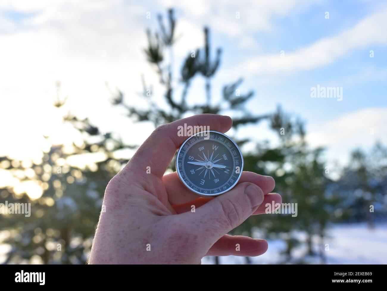Compass in hand on snow background. Orientation on terrain in forest ...
