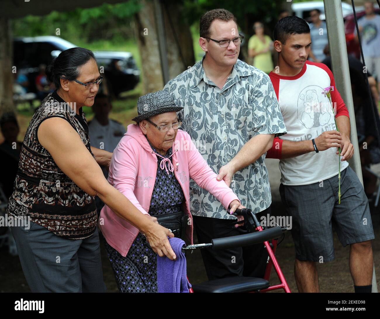 Guam's Lt. Gov. Ray Tenorio walks with Ana San Nicolas Ungacta to place ...