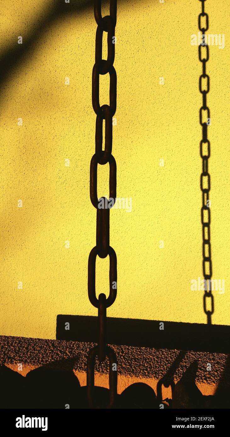 A vertical shot of metal chain shadows on a yellow wall Stock Photo - Alamy