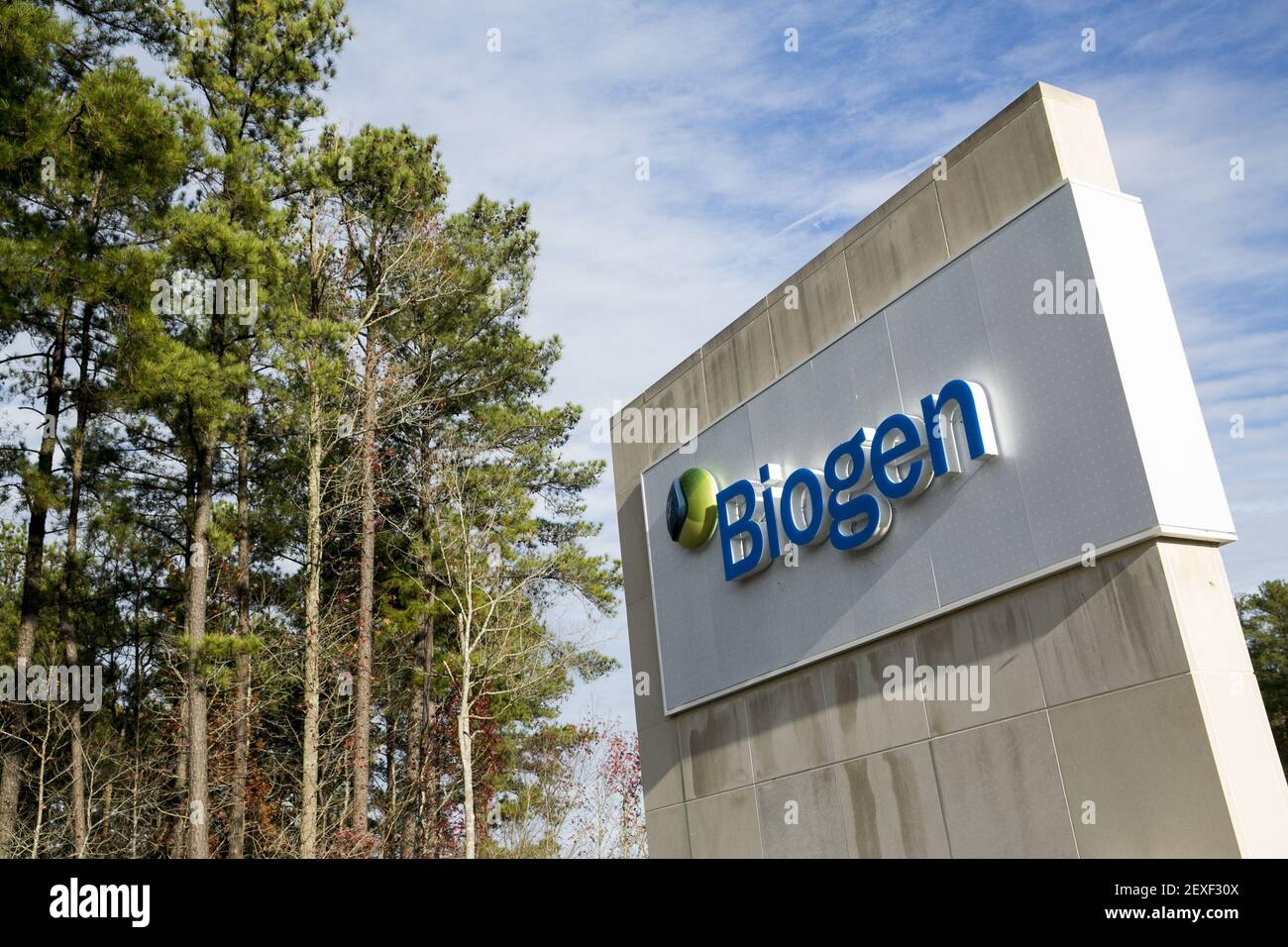 A logo sign outside of a facility occupied by Biogen in Research ...