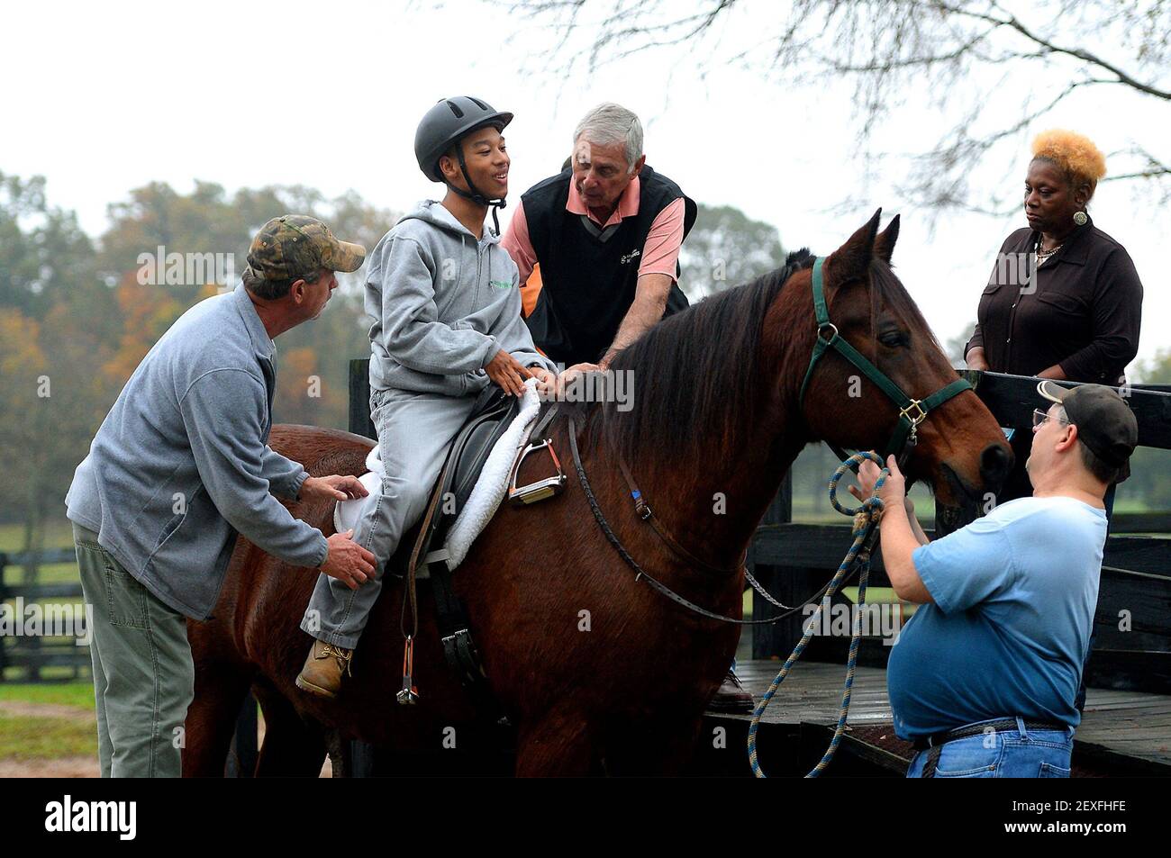 Chancellor Lee Adams, center, is helped onto Raider, a Cleveland Bay by ...