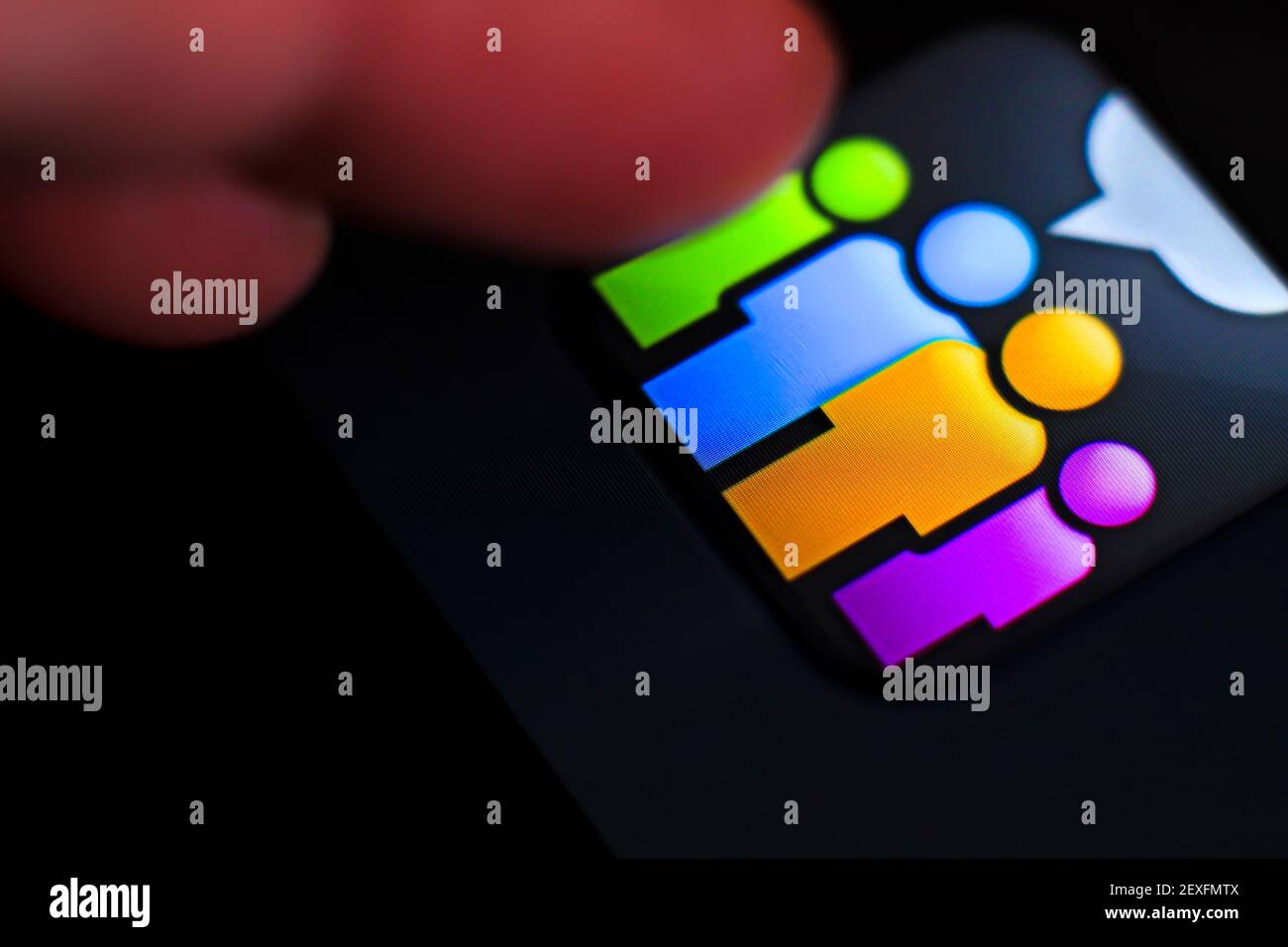 Madrid, Spain- March 3, 2021: Finger pressing Loopt app icon on black ...