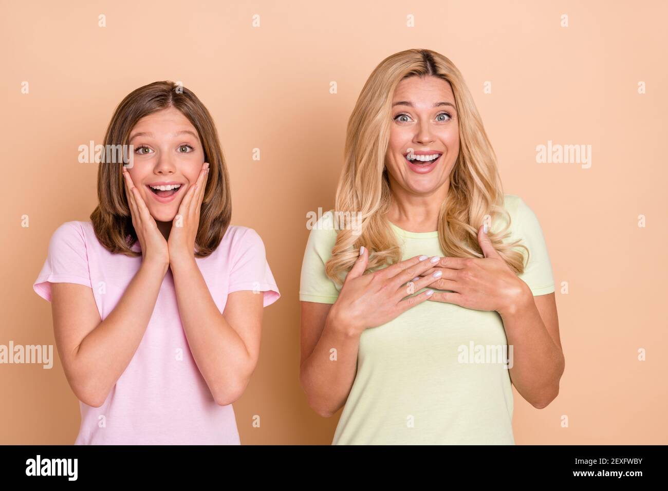 Photo of amazed mother and daughter hold hands chest cheeks news sale ...