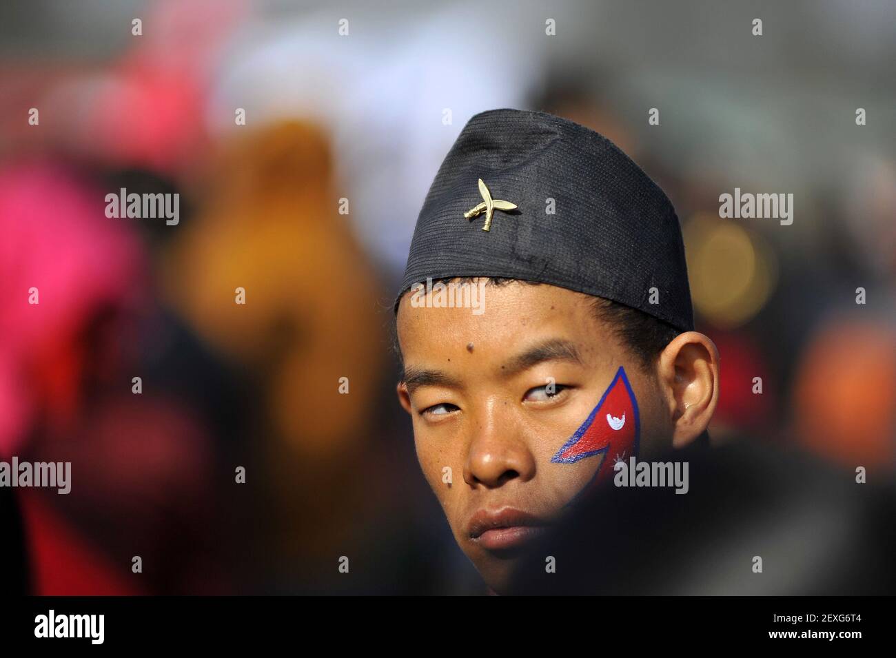 A Gurung youth in a traditional attire face painted Flag of Nepal ...