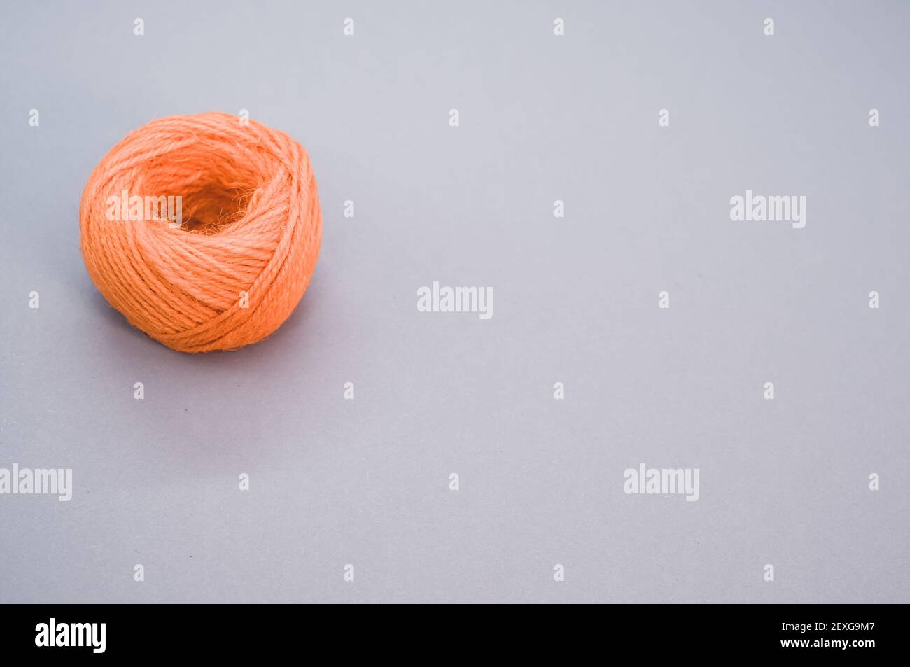 An orange thread yarn isolated on a grey background Stock Photo - Alamy
