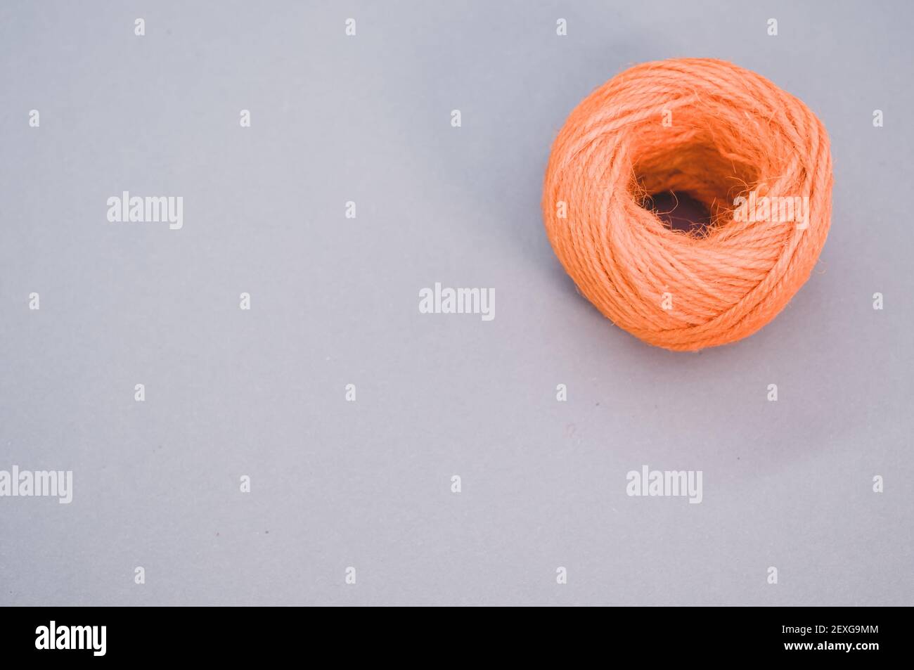An orange thread yarn isolated on a grey background Stock Photo - Alamy