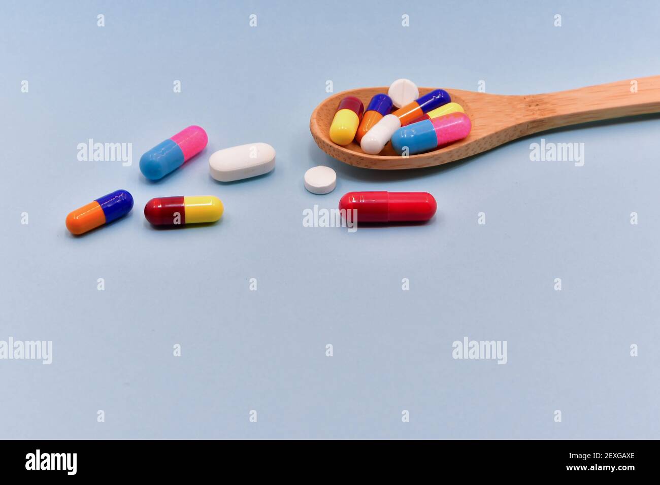 Original photograph of drugs on light blue background and wooden spoon ...