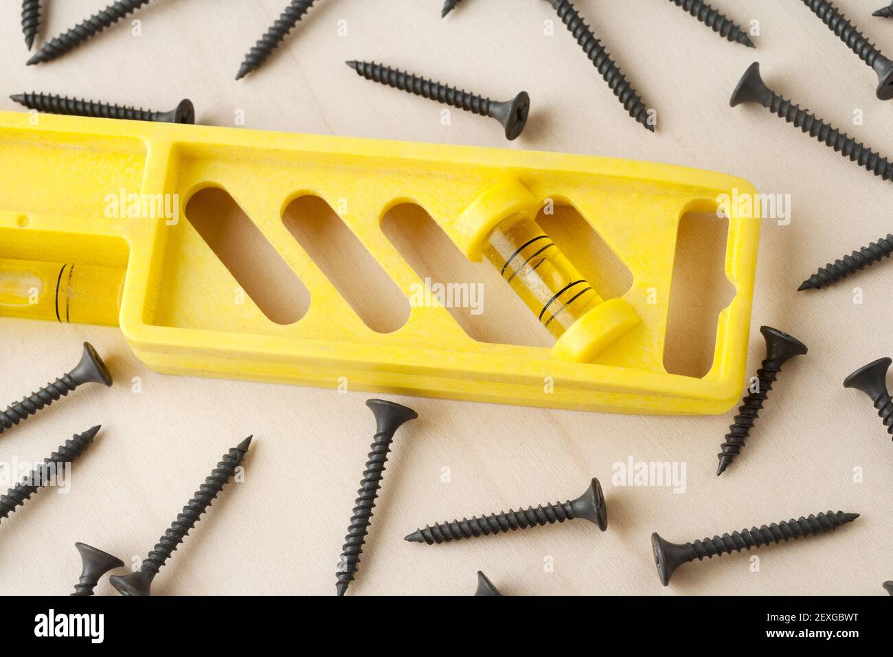 Screw nails and a bubble level Stock Photo - Alamy