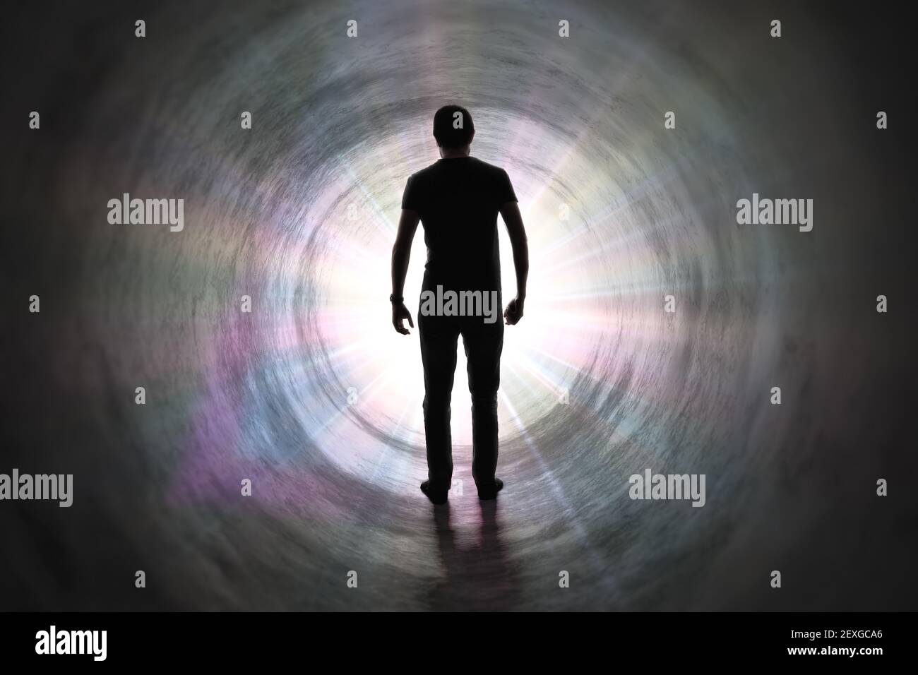 Life after death concept. Silhouette of man's soul is walking to bright ...