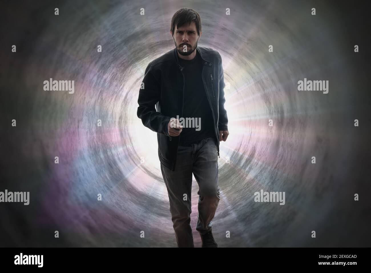 Young man is running away from death. Bright gods rays in tunnel in ...