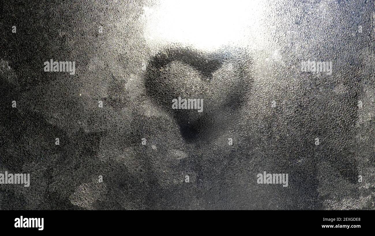 Frost on window with image of heart drawn by finger Stock Photo - Alamy