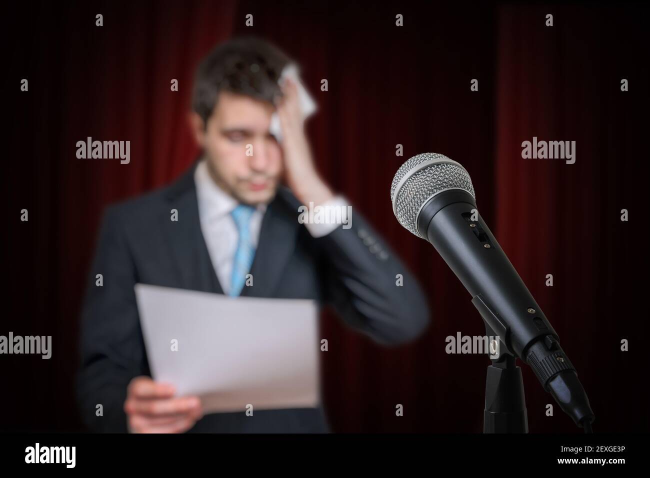 Nervous speaker is afraid of public speech and is sweating. Microphone ...