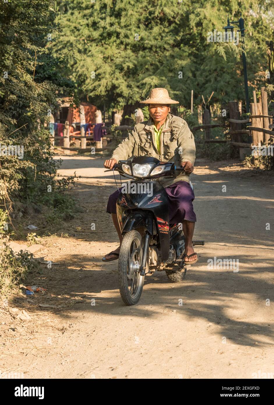Local man on motorcycle in village, Myanmar Stock Photo - Alamy