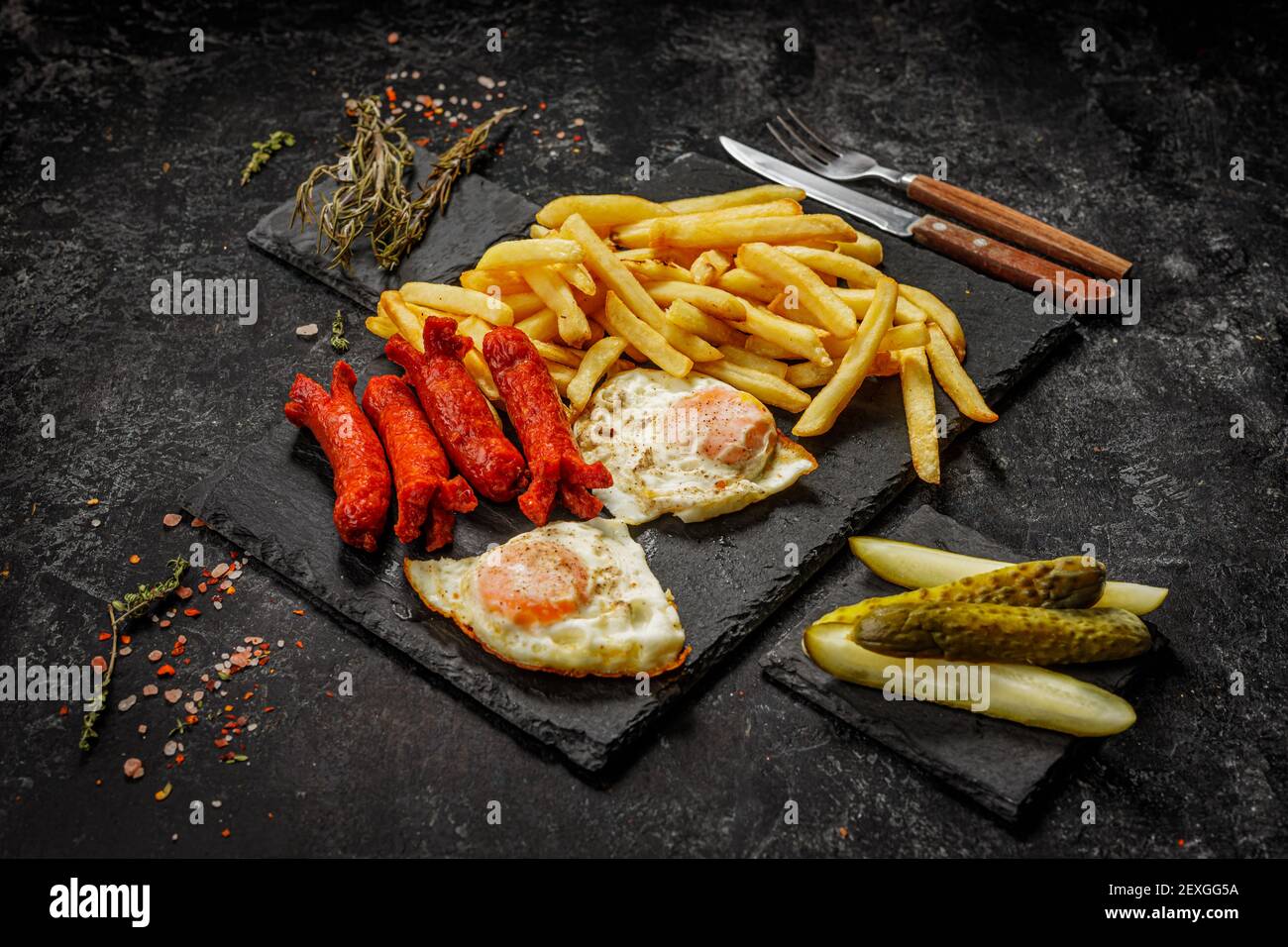 close up of a black plate of fried egg with french fries. Fast food ...
