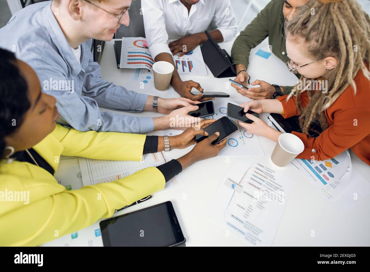 Close up of multiracial team using smartphones at work Stock Photo - Alamy