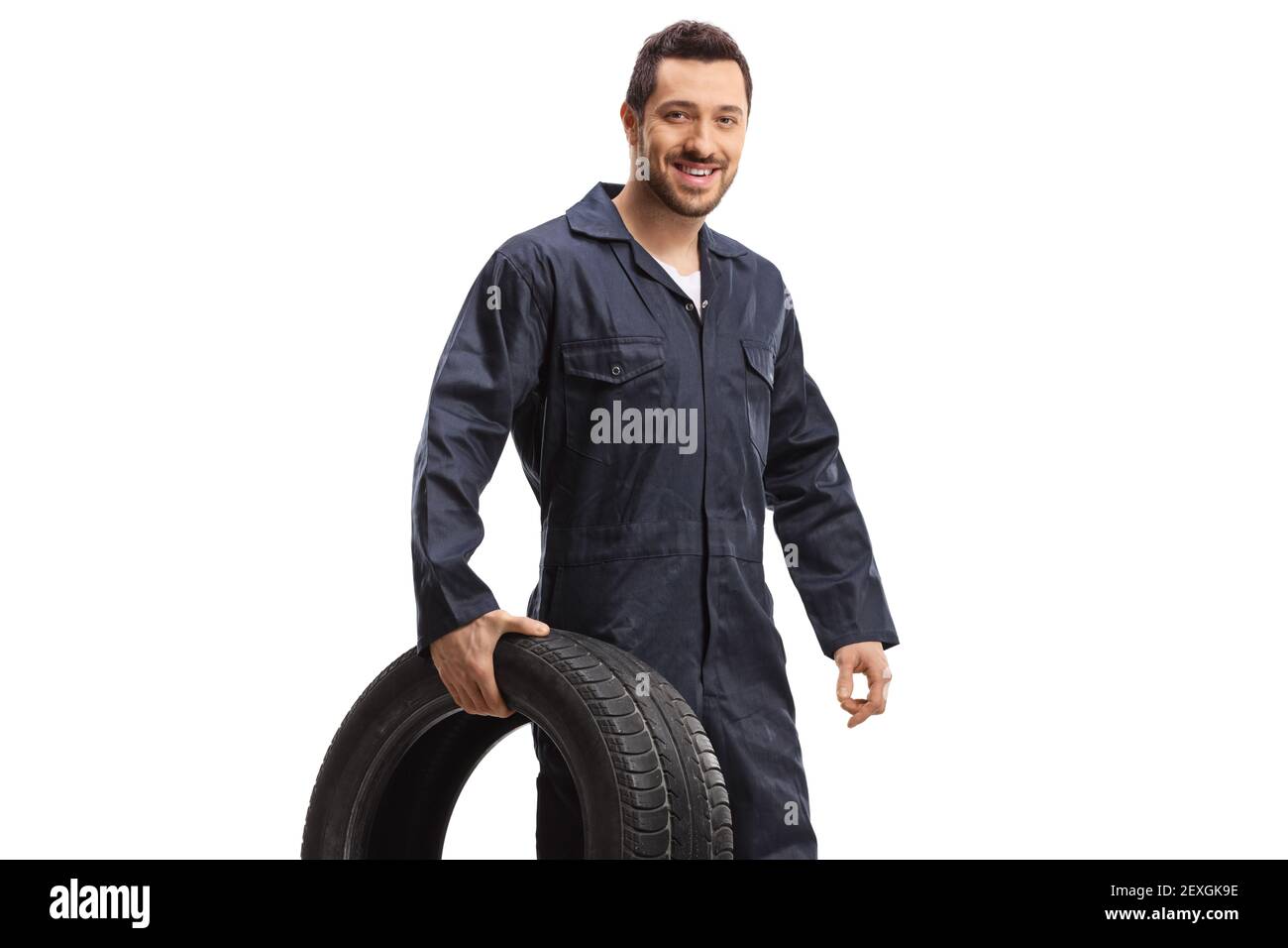 Auto mechanic smiling and holding a tire isolated on white background ...