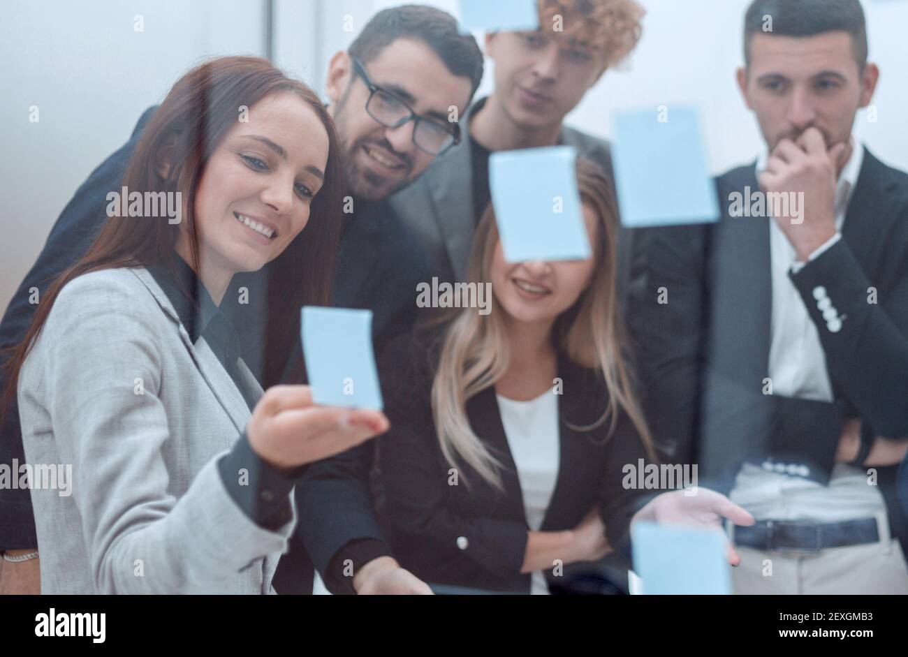 employees discussing sticky notes on the glass Stock Photo - Alamy