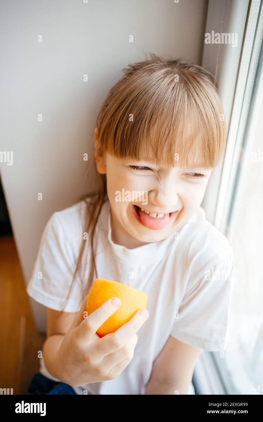 girl's reaction to tasting fresh lemon Stock Photo - Alamy