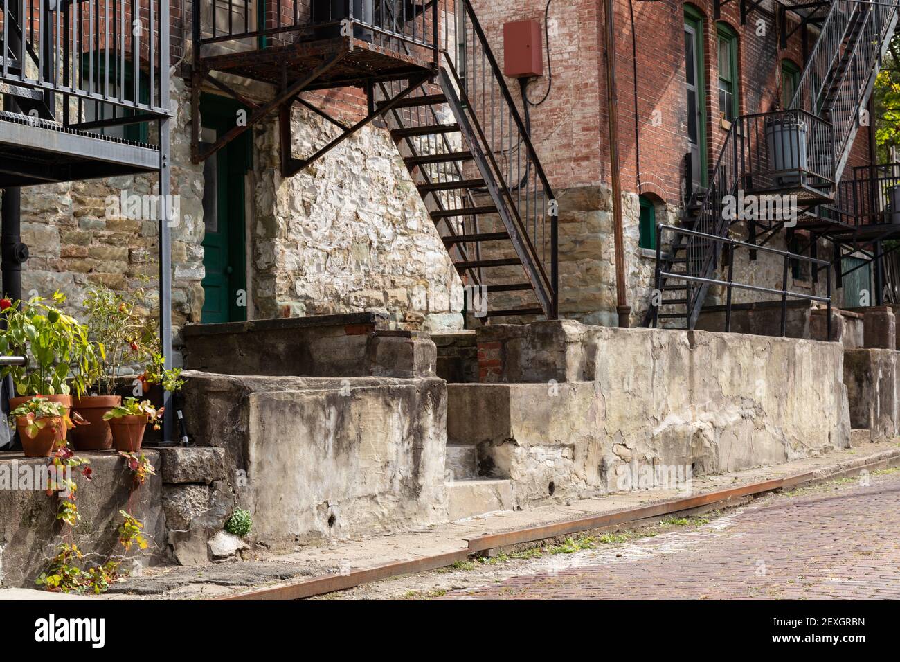 Rusted metal fire escape stairs and crumbling concrete steps at the ...