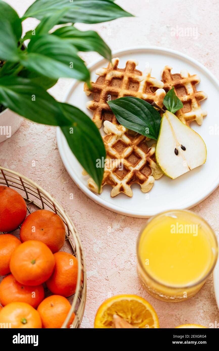 homemade waffles on a light pink background. orange juice. fruit Stock ...