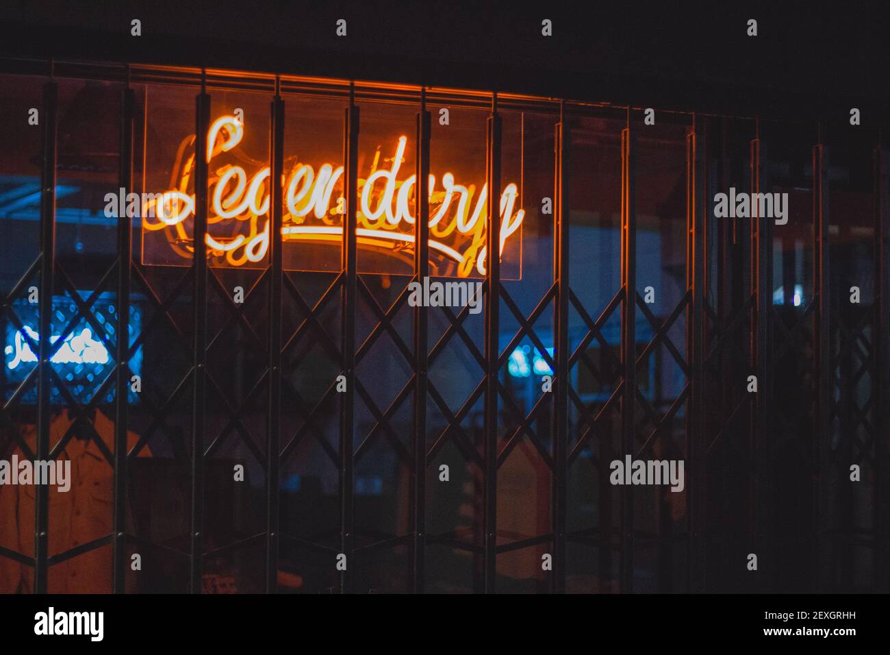 a neon writing of a Legendary sign behind bars in the night Stock Photo ...