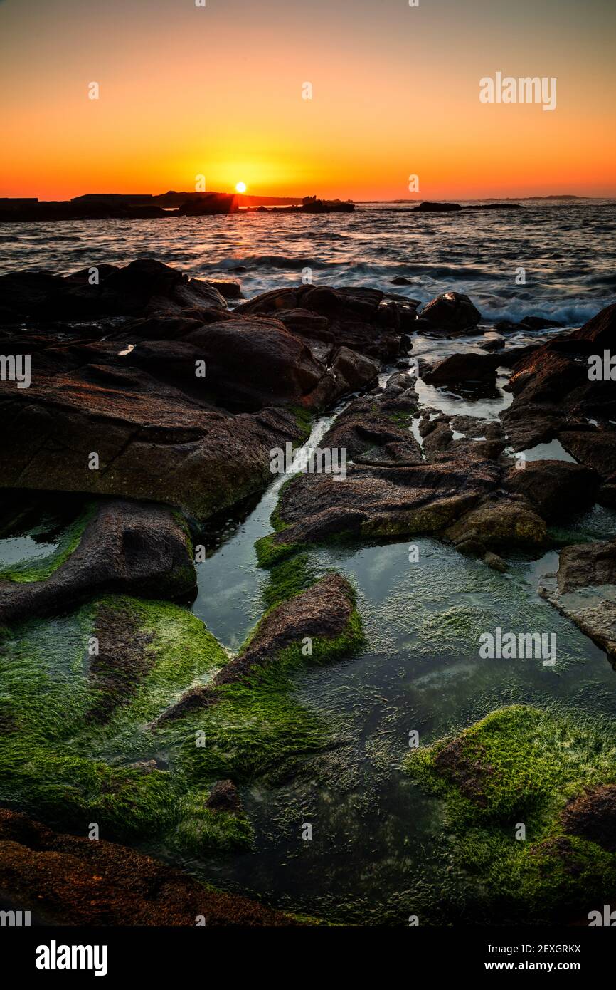 Sunset on a beach with rock formations on the Galician coast Stock ...