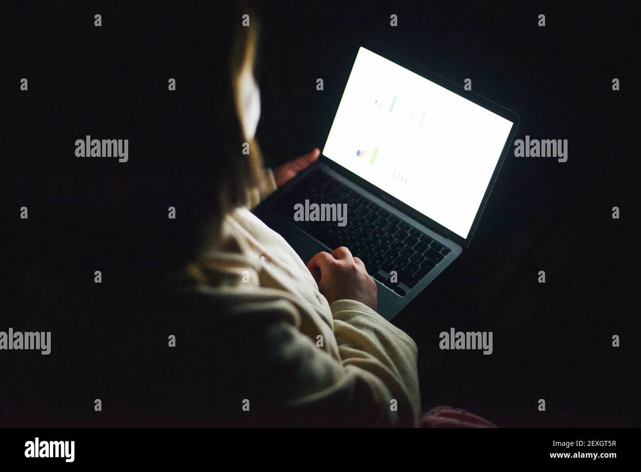 Anonymous woman working on laptop at night Stock Photo - Alamy
