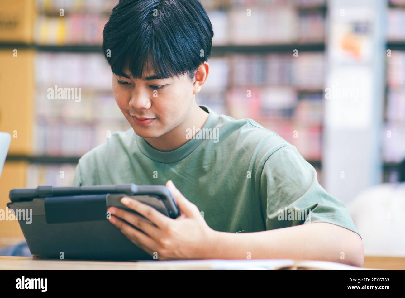 Young collage student using computer and mobile device studying Stock ...