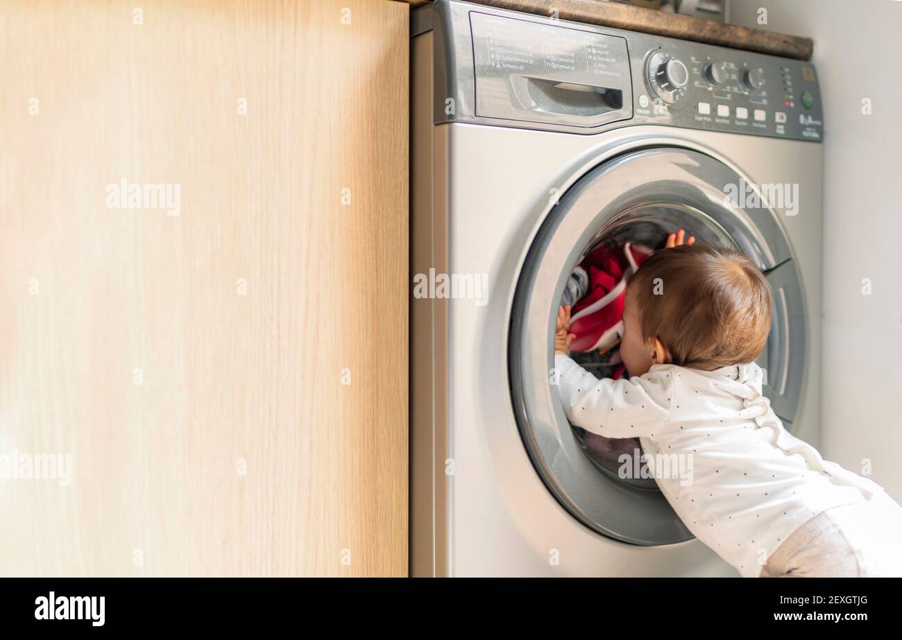 little girl looking at washing machine Stock Photo - Alamy