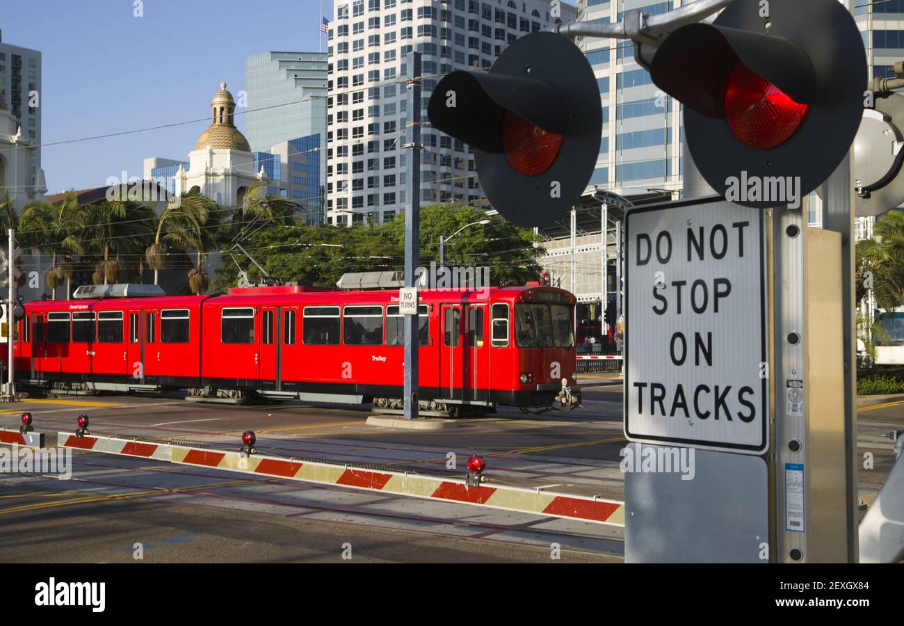 Downtown Scene at RailRoad Crossing Red Trolley Car Passing Signal ...